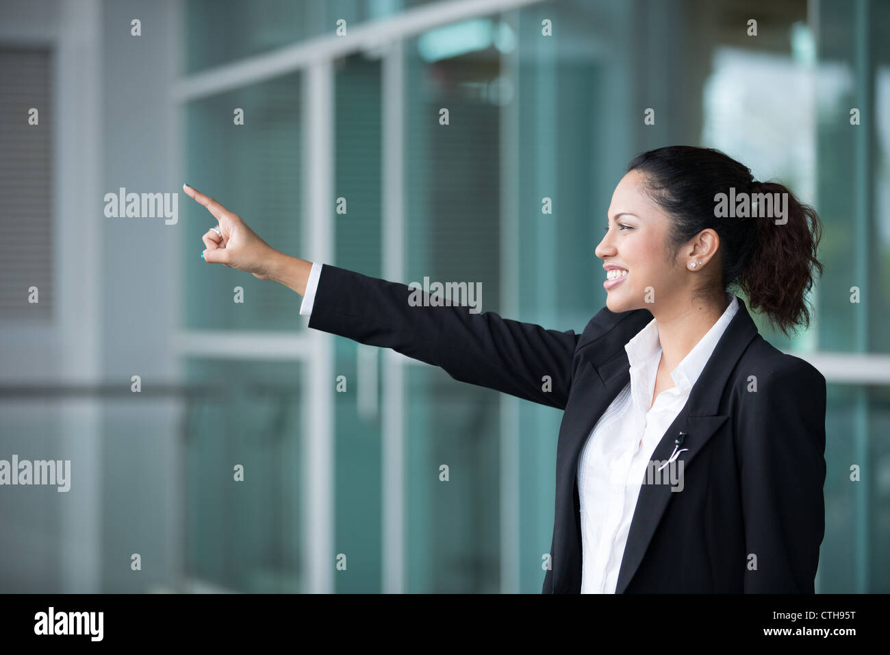 Portrait of Indian business woman pointing with her arm out stretched ...
