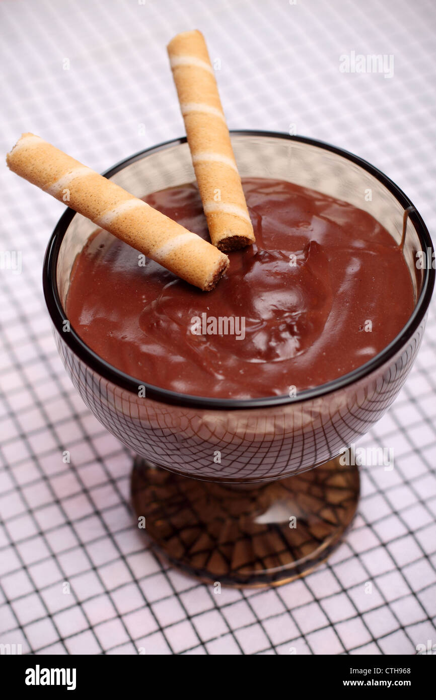 Bowl of homemade chocolate pudding with creme-filled waffle rolls Stock ...