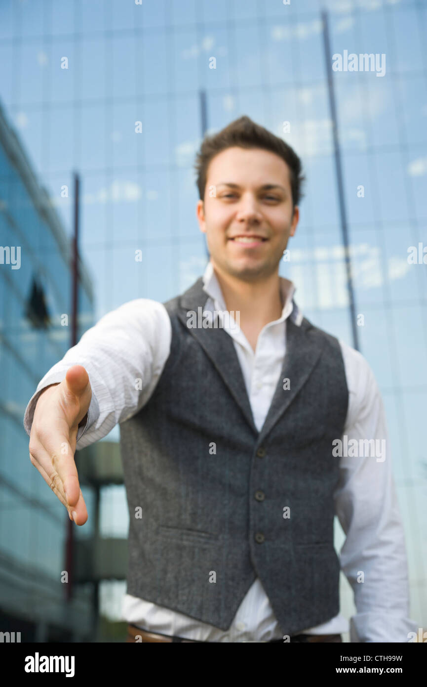 Young smiling confident man offering hand for handshake Stock Photo - Alamy