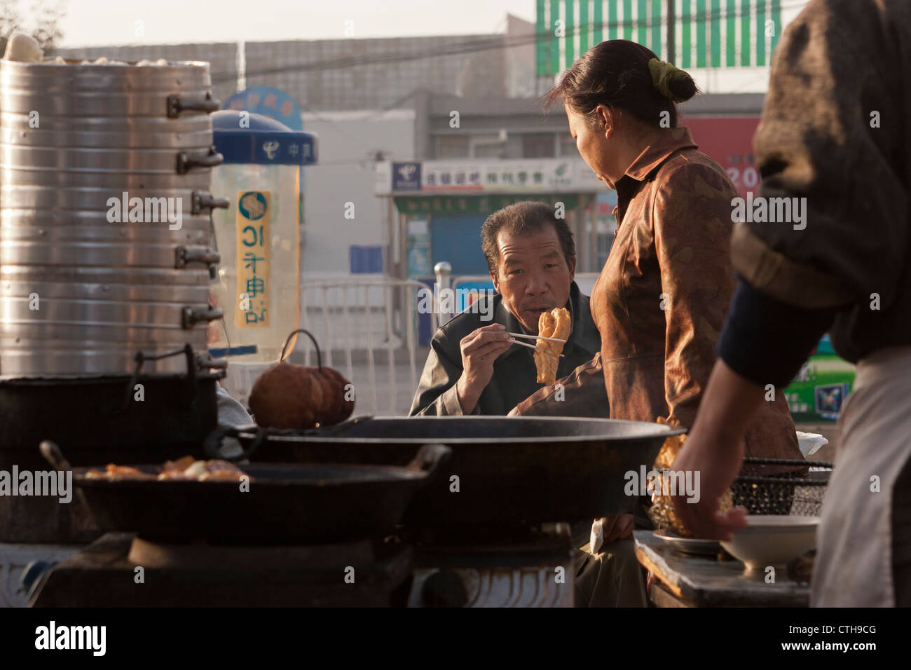 Han Chinese eat breakfast at an outdoor stall in Turpan, Xinjiang ...