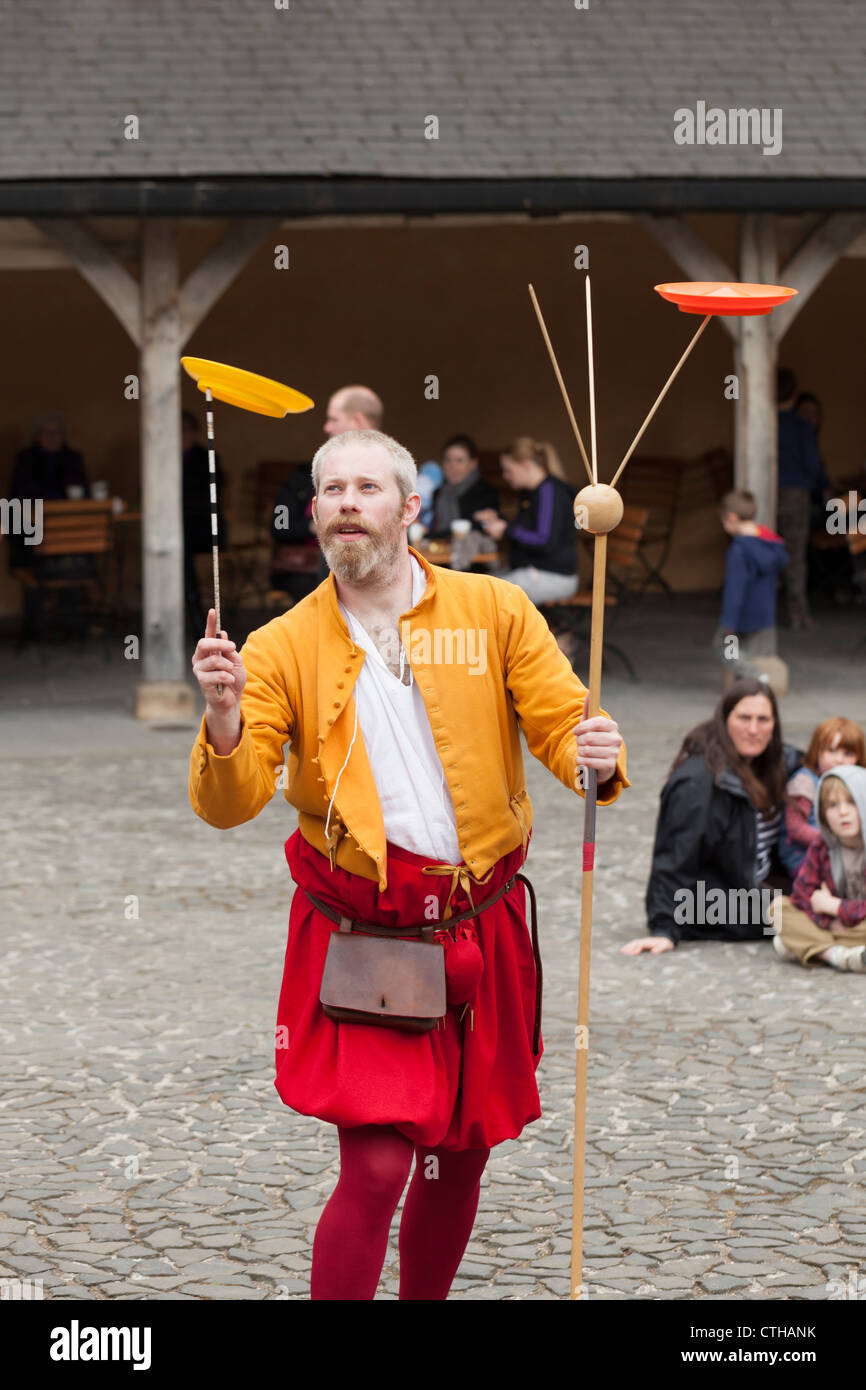 Juggler in historic costume entertains crowd by spinning plates Stock ...