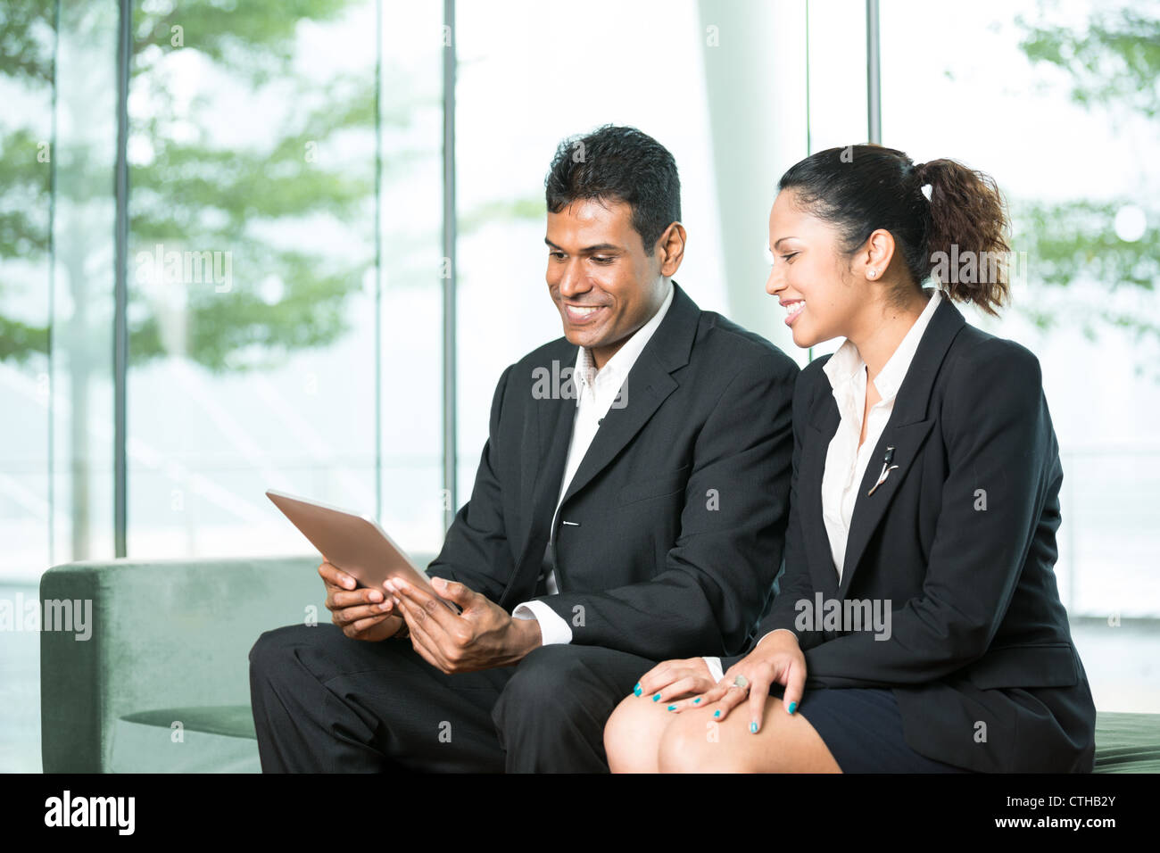 Indian Business people looking at a digital tablet Stock Photo - Alamy
