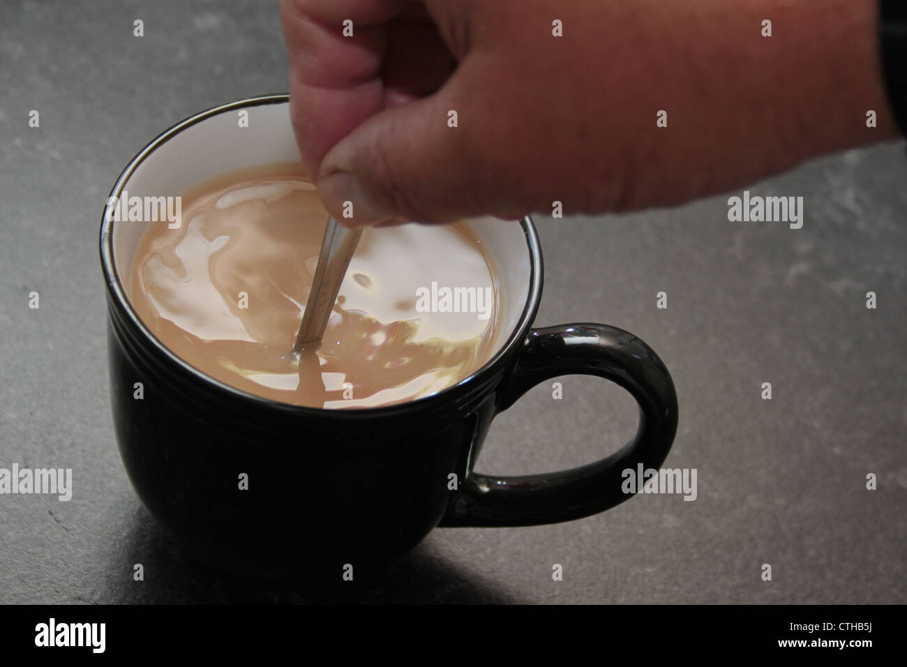 Coffee mug with close up of hand stirring hi-res stock photography and ...