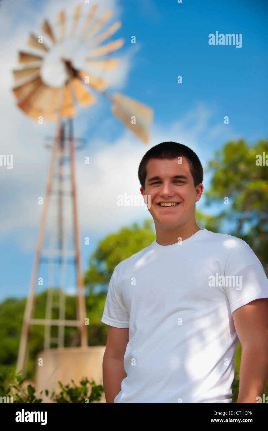 American male teenager in front of ranch wind turbine on a farm Stock ...