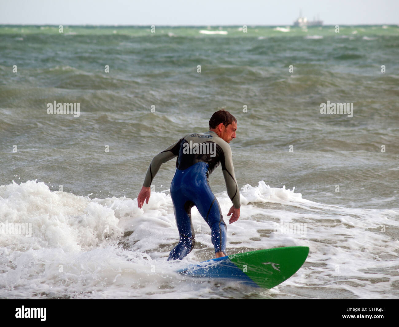 A surfer rides waves in the sea near to Brighton,England Stock Photo ...