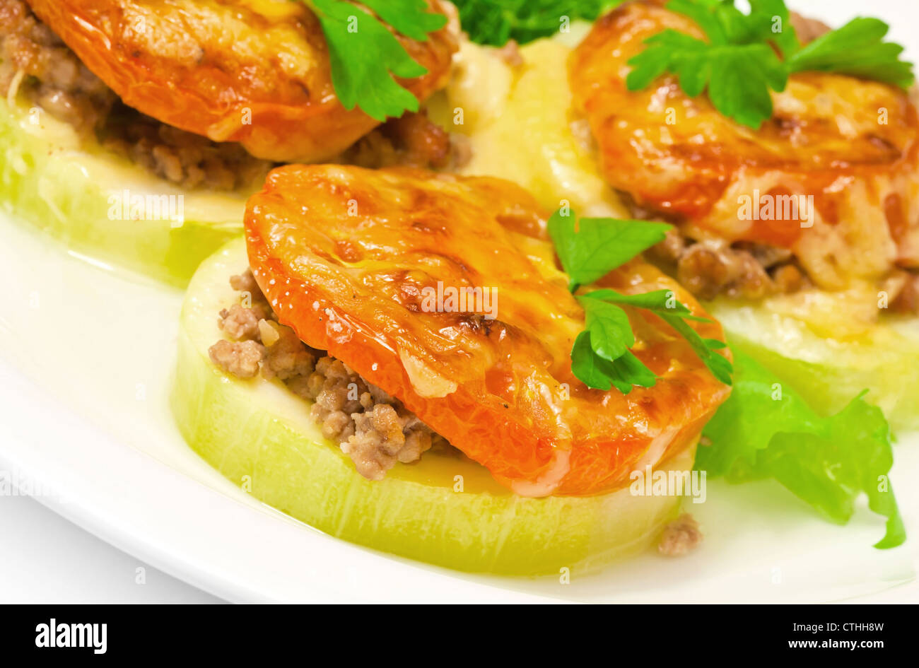 Backed vegetable marrow stuffed with meat, tomato, cheese and greens on ...