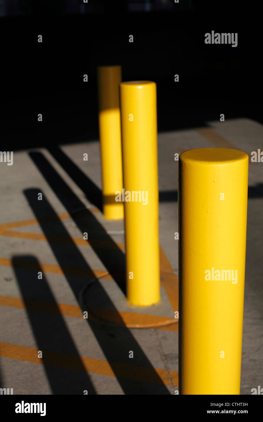 Yellow parking bollards Stock Photo - Alamy