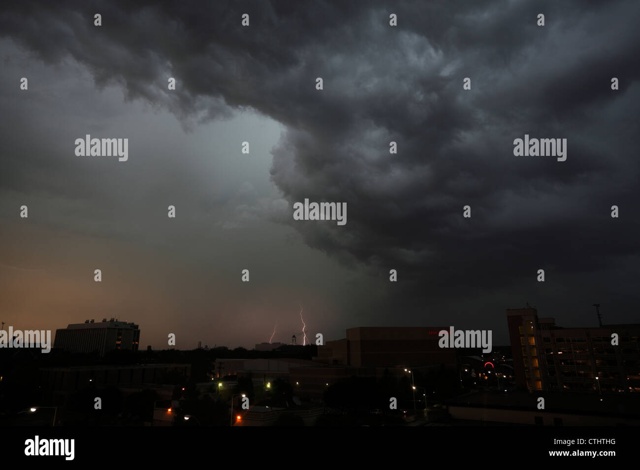 Squall line moves over a city, showing a remote strike of lightning ...