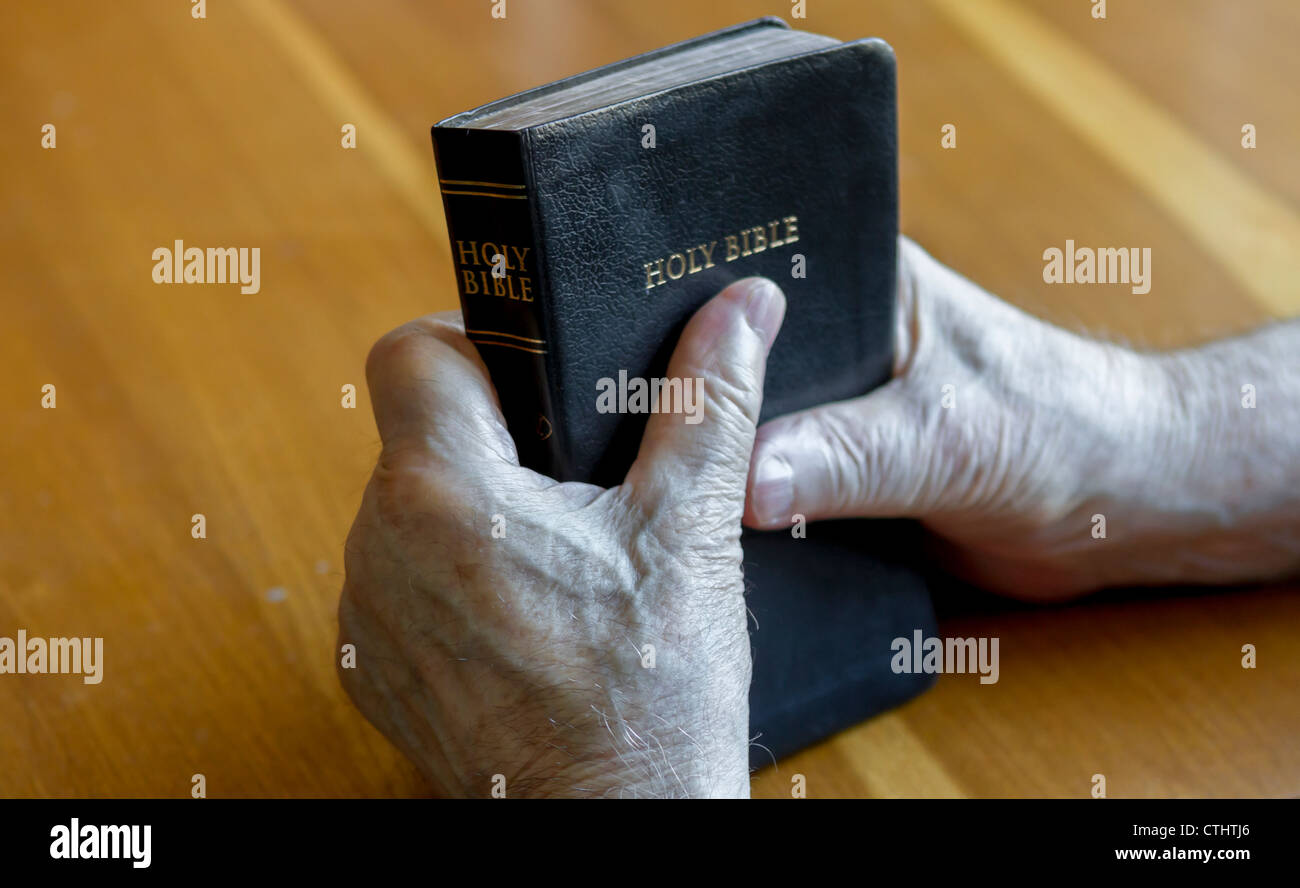 holding the bible over table Stock Photo - Alamy