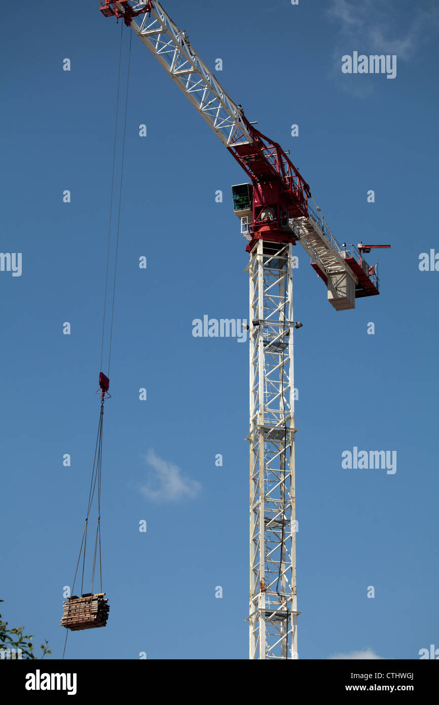 Tower crane hoisting a load Stock Photo - Alamy