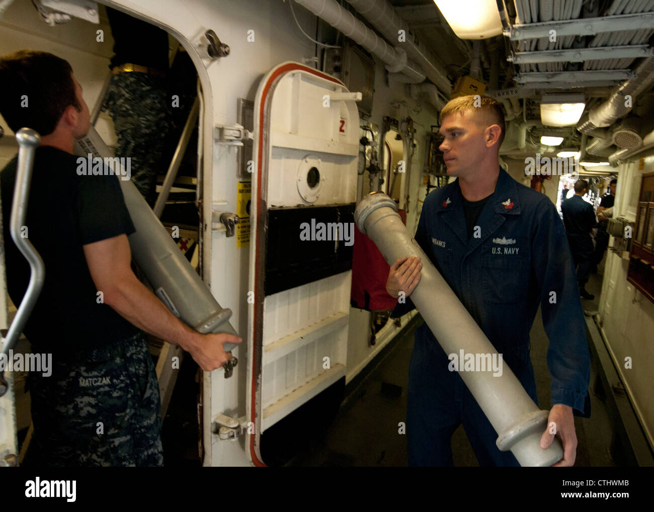 Fire Controlman 1st Class Dennis Fairbanks, right, waits to pass a MK ...