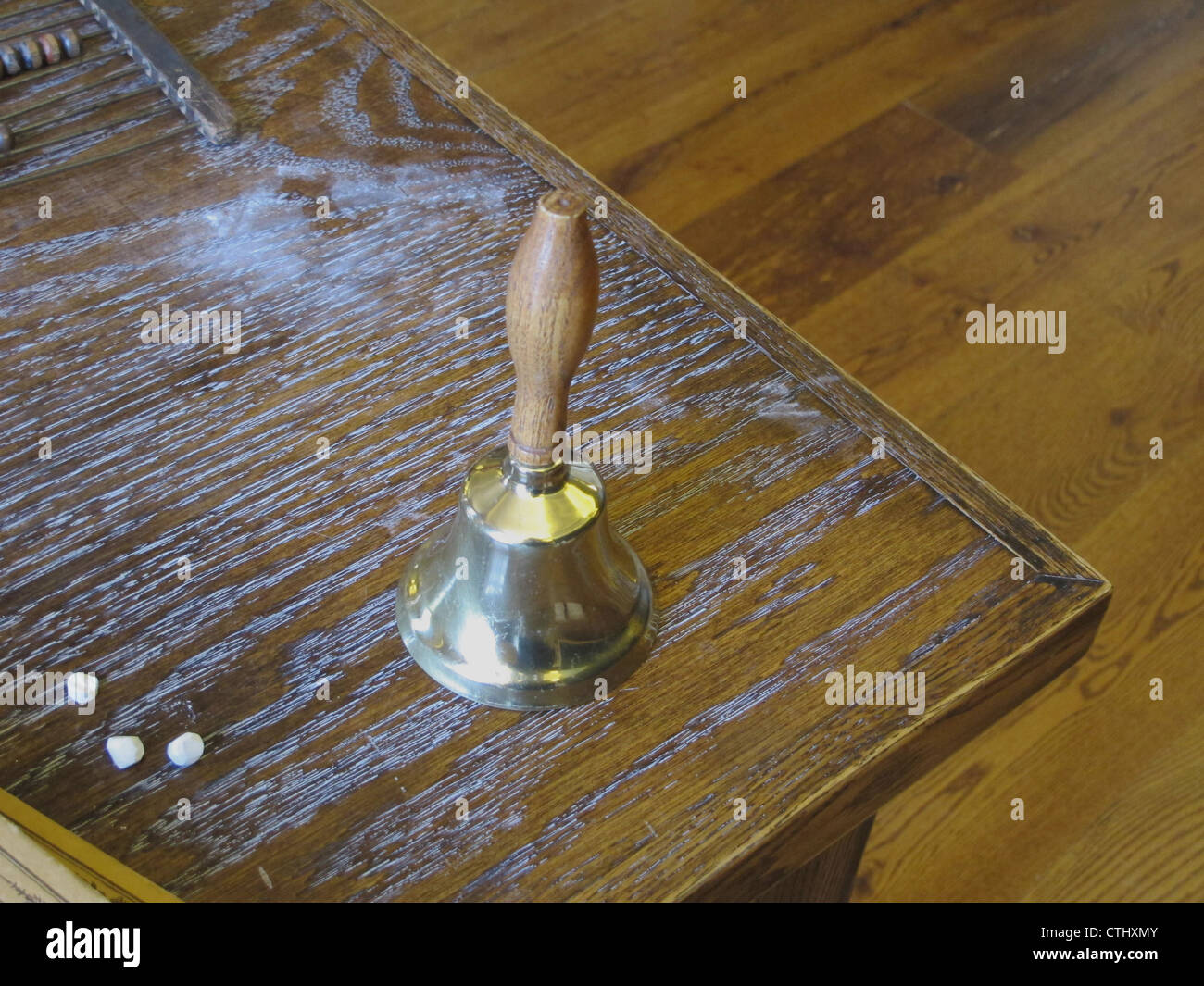 Classroom Bell and bits of chalk set on the teacher's desk in the ...