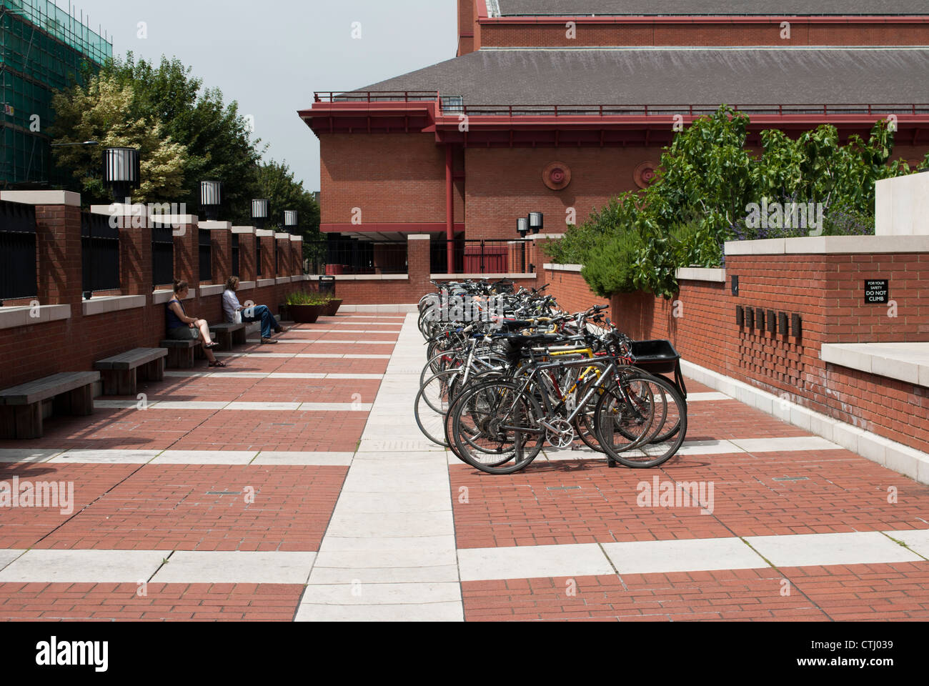 Rack of bicycles at British Library with people sat on benches Stock ...