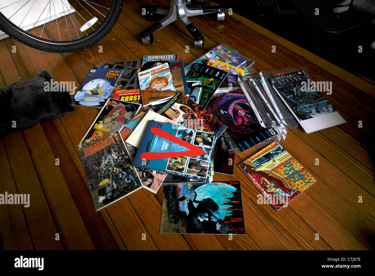 Pile of comic books on a floor with a cat Stock Photo - Alamy