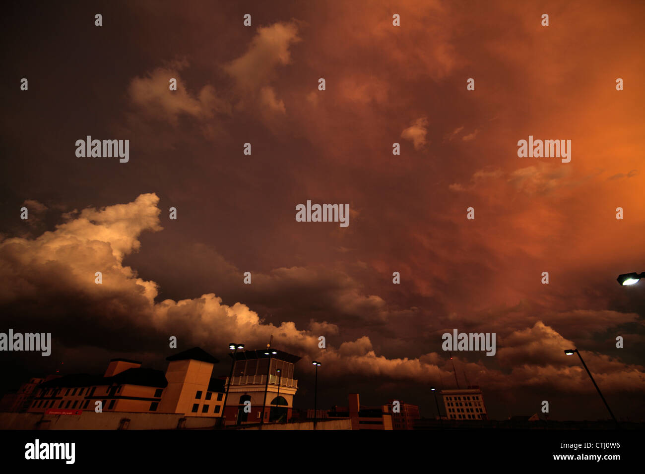 A storm system over city buildings leaving an orange glow, colors not ...
