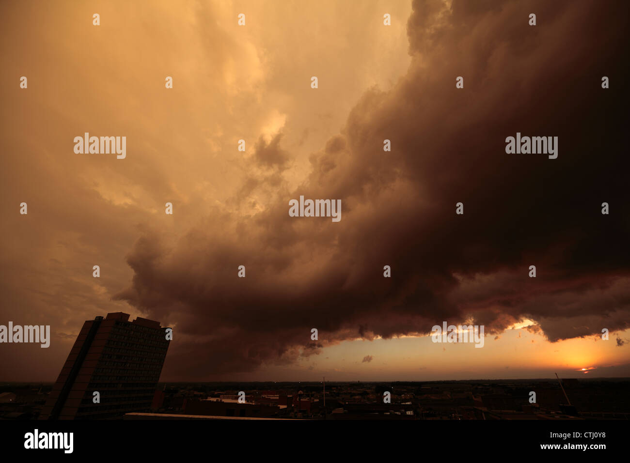 A squall line flies over a city building at sunset--colours not ...