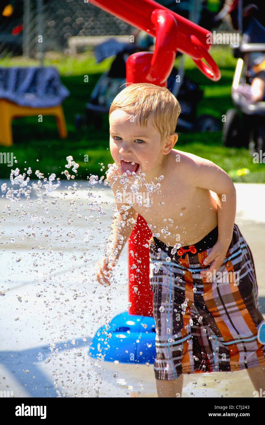 A Young Boy Playing In A Splash Park; Three Hills, Alberta, Canada ...