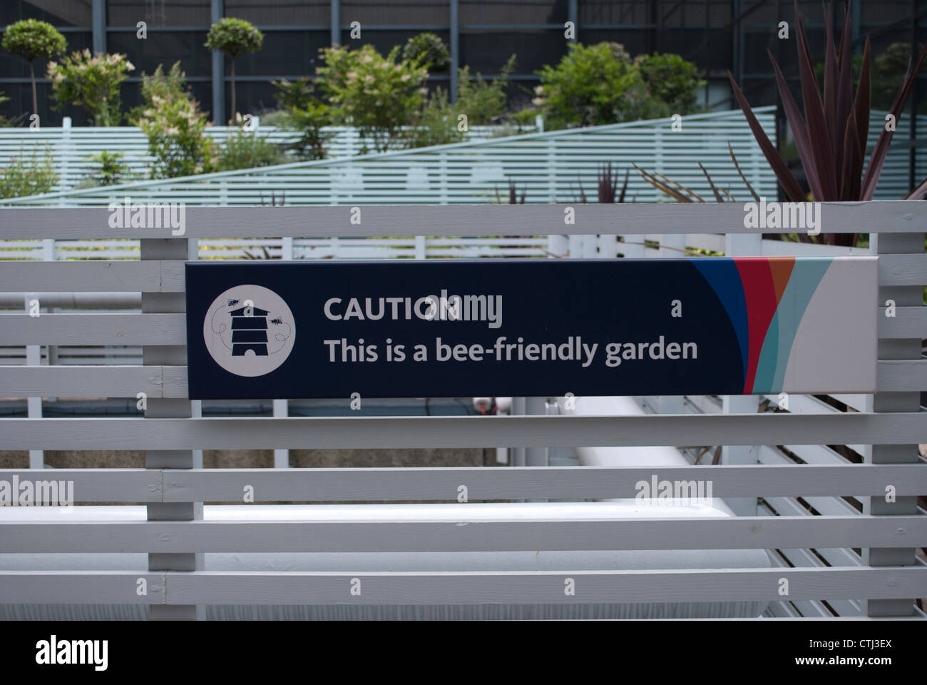 'CAUTION This is a bee friendly garden' sign on white painted wooden ...