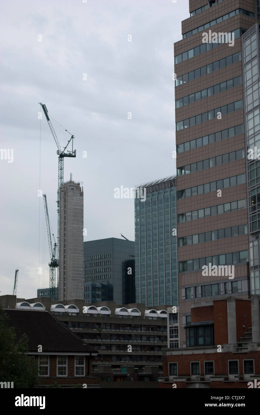 Office block being build with two tower cranes next to other office ...