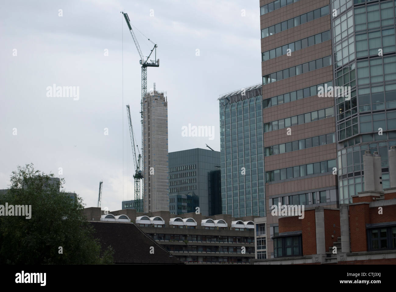 Office block being build with two tower cranes next to other office ...