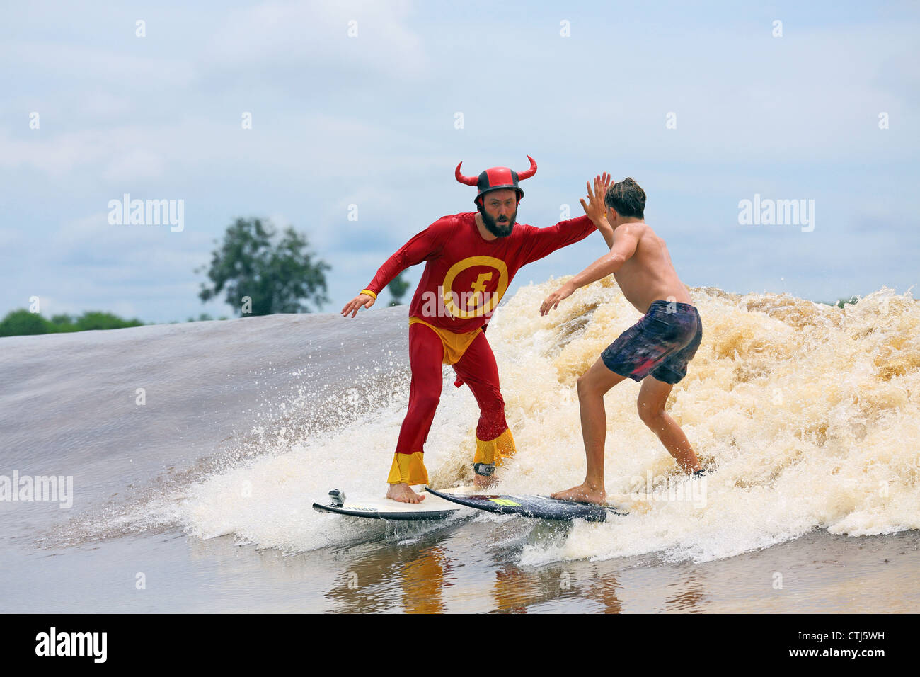 Two surfers high-five while surfing a river tidal bore known as the 7 ...