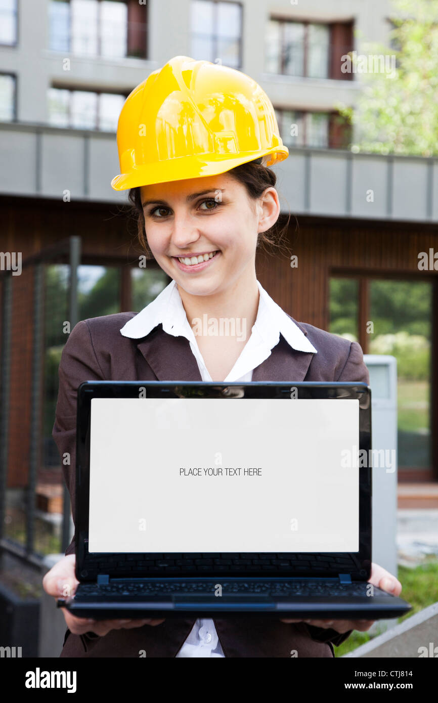 Female construction engineer show something on laptop Stock Photo - Alamy