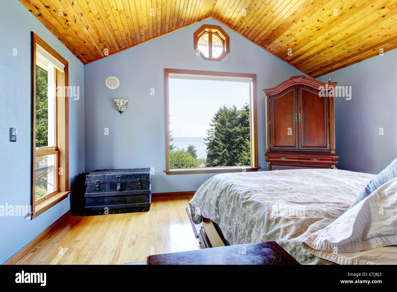 Blue bedroom with wood ceiling and bed, large windows interior Stock ...