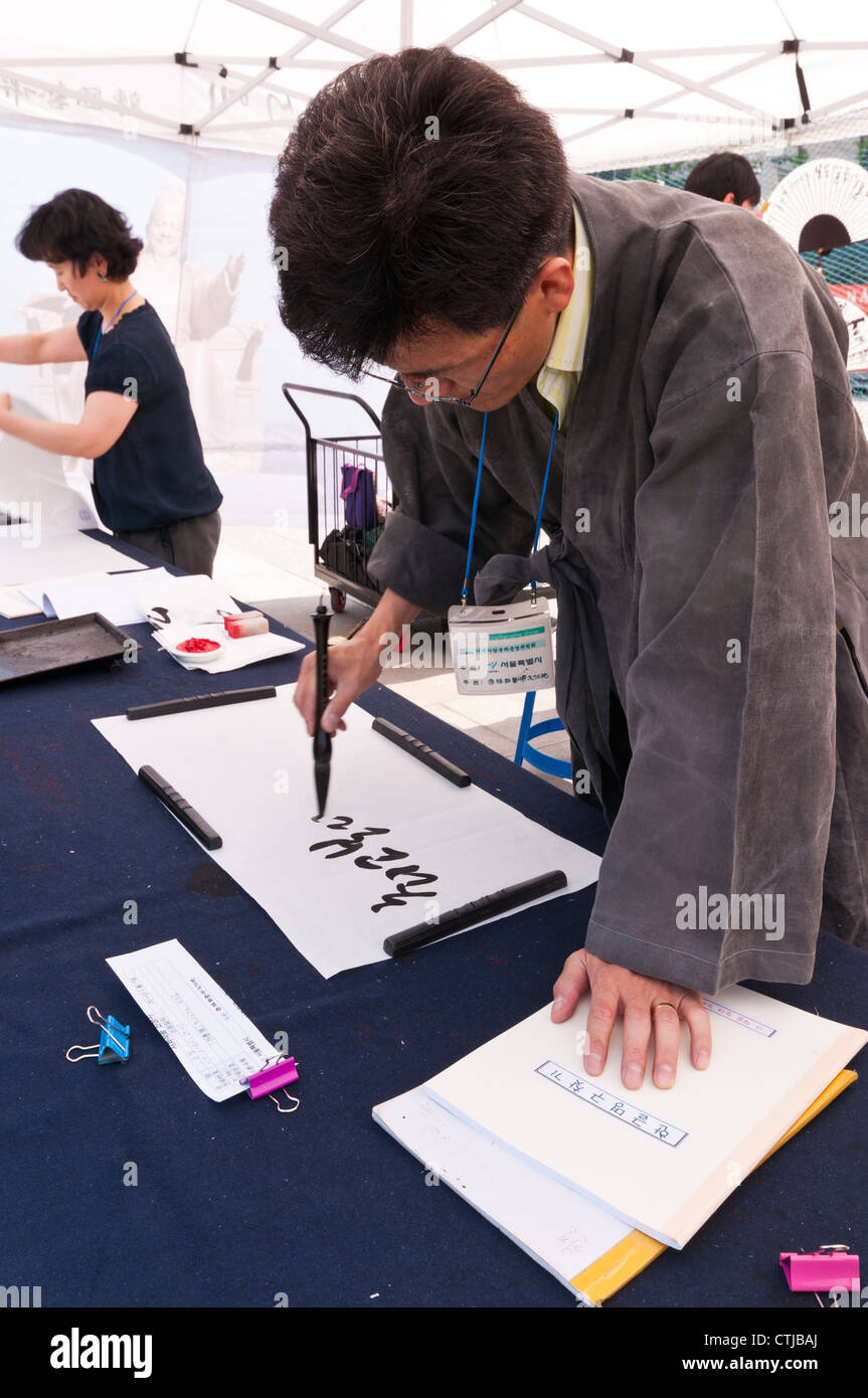 Korean calligrapher in traditional clothes demonstrates his art at the ...