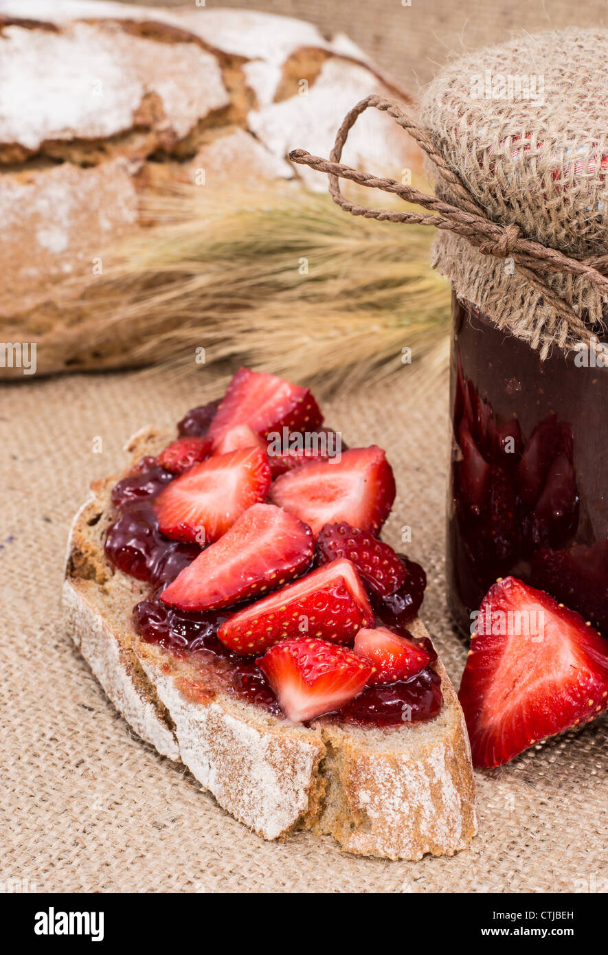 Bread with Strawberry Jam on rustic background Stock Photo - Alamy