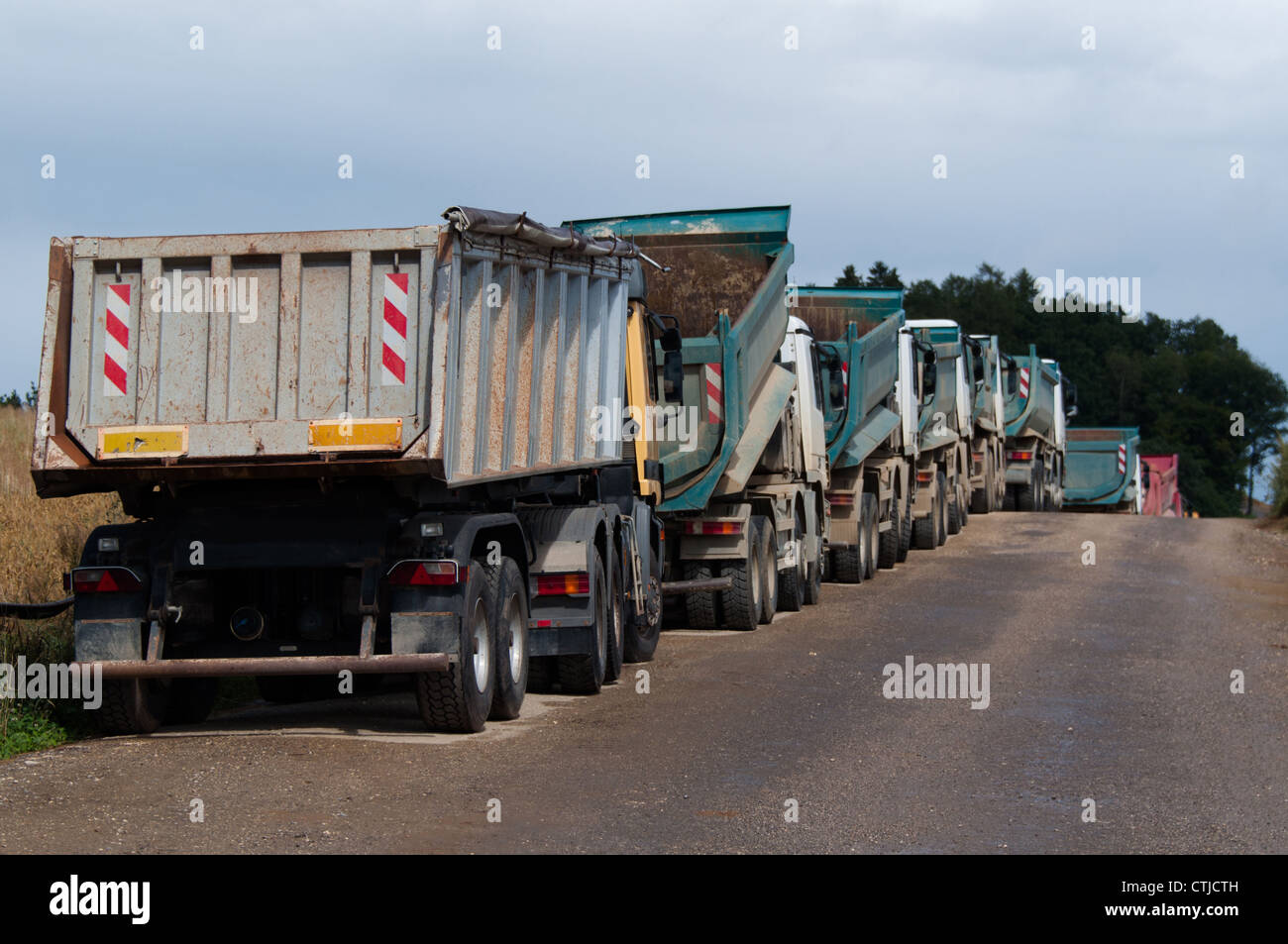 Row of Dump Trucks and Earth Moving Equipment at a Highway Construction ...