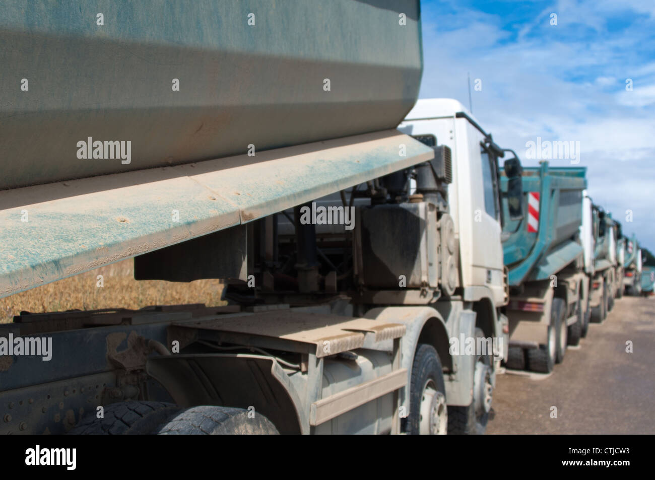 Row of Dump Trucks and Earth Moving Equipment at a Highway Construction ...
