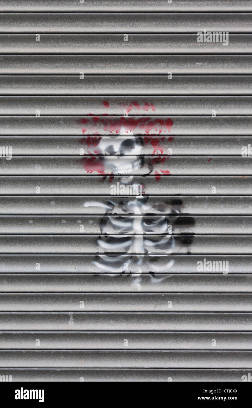 Street art skeleton with red hair graffiti sprayed on metal shutter ...