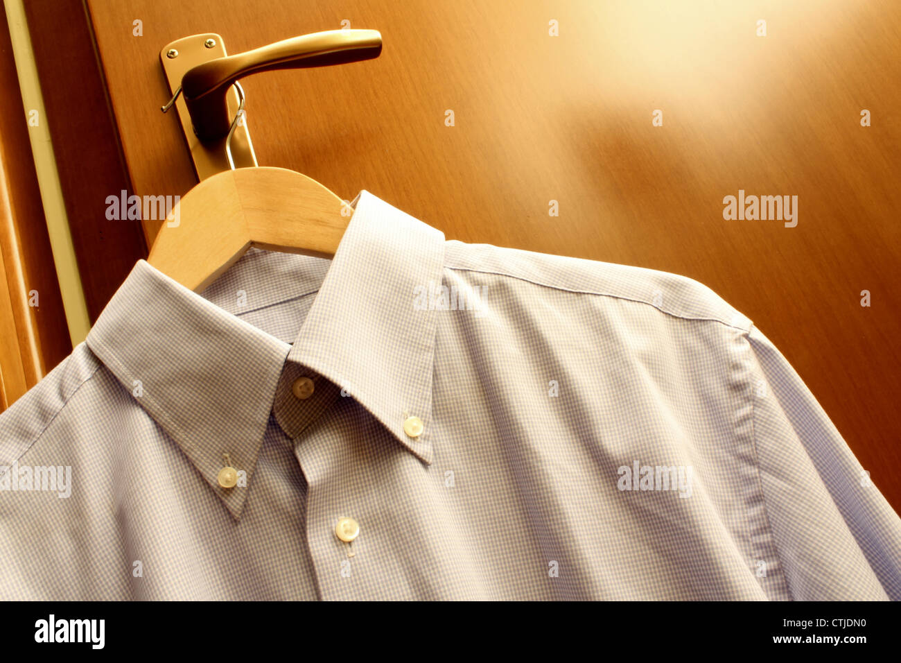 Shirt with hanger hanging from a wooden handle Stock Photo - Alamy