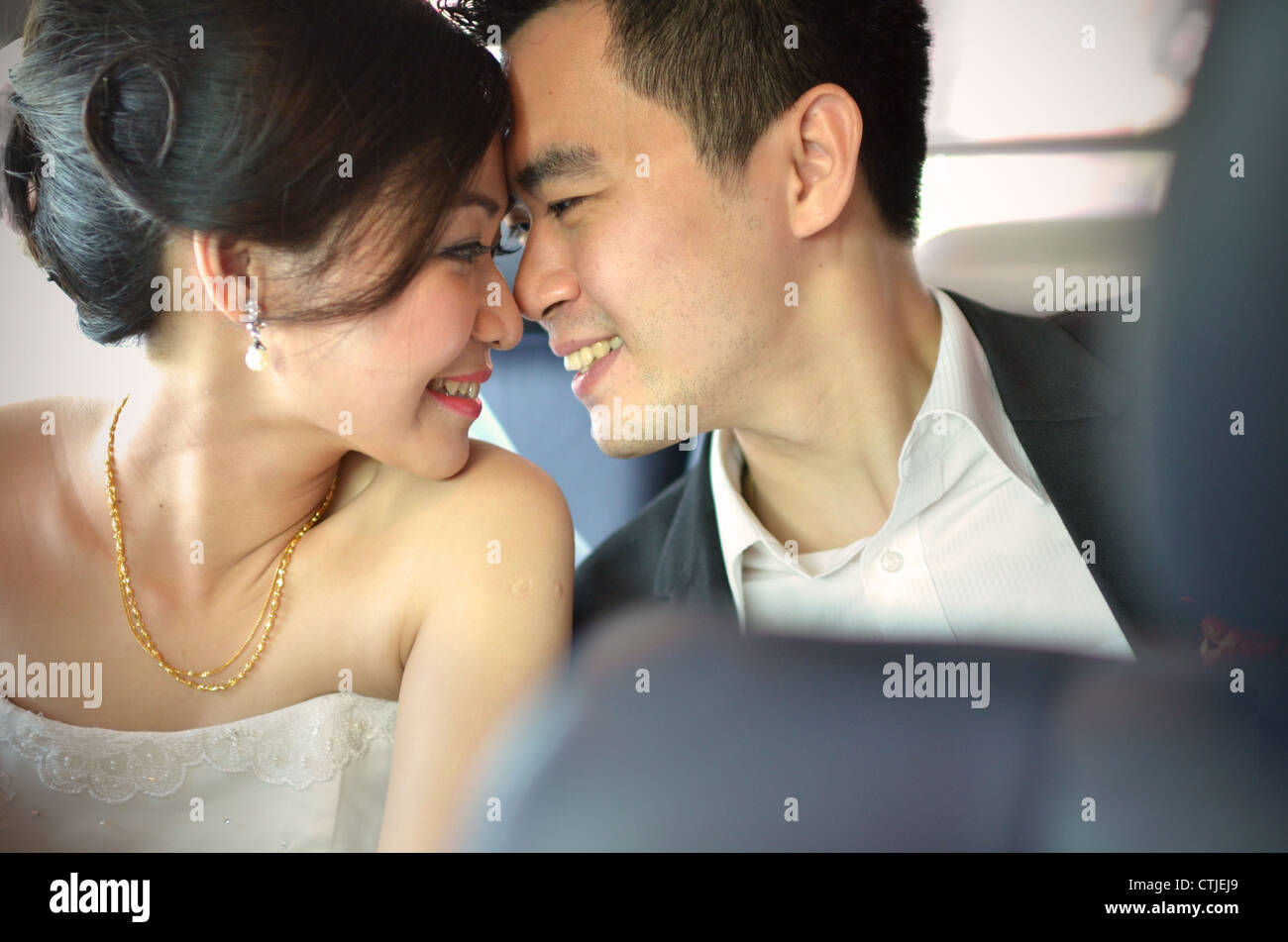 A bride and groom going kissing on their wedding day, with bokeh on the ...