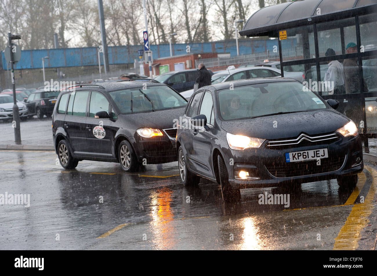 Taxi waiting for a car to move away from a taxi rank on a rainy day ...