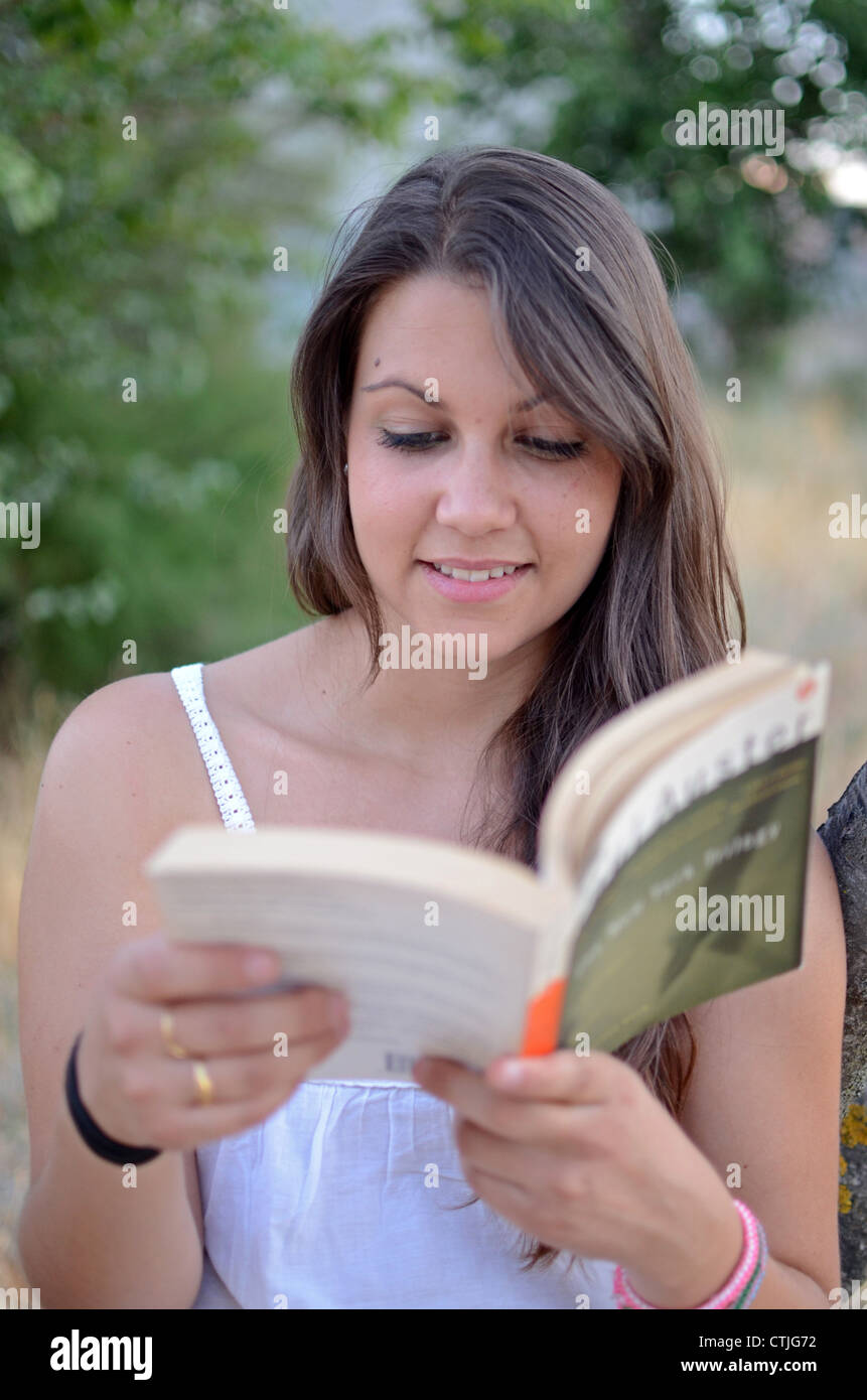 Young cute woman reading a book in nature Stock Photo - Alamy