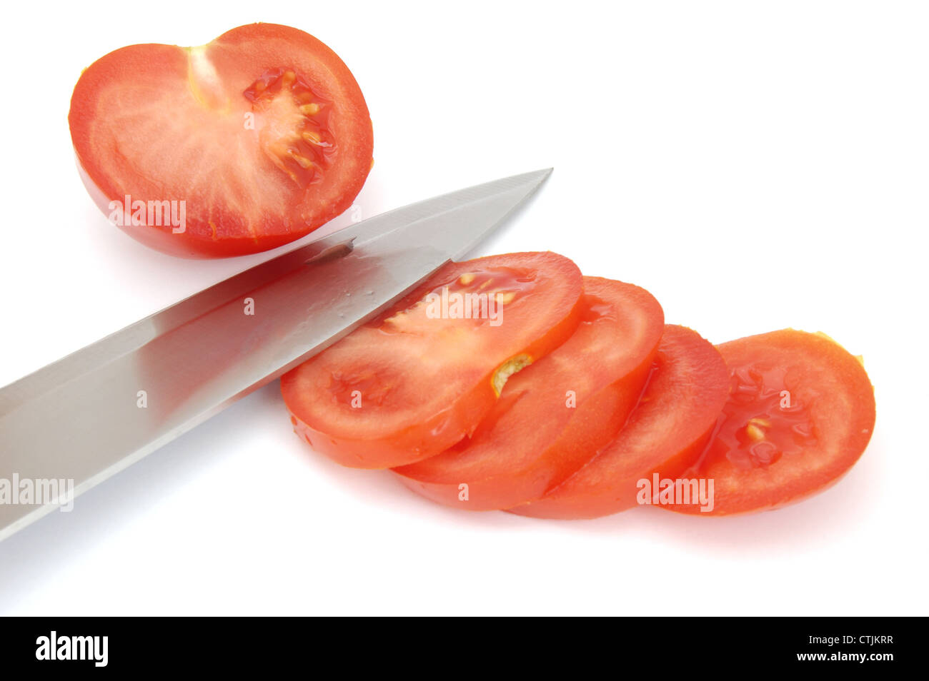 Sliced tomato and knife blade isolated on a white background Stock ...