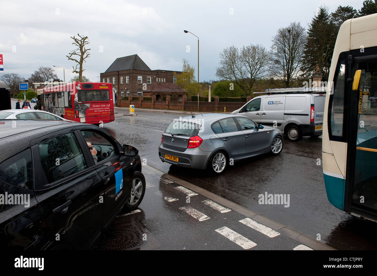 Traffic pulling out between two buses at a junction on a busy road in ...