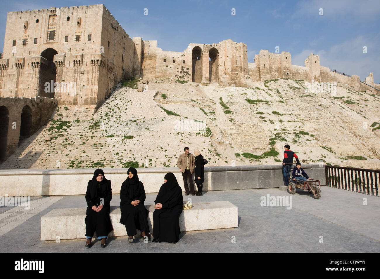 Muslim women sitting in front of the Citadel of Aleppo, in Syria Stock ...