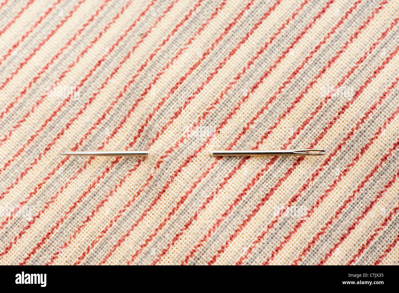 Sewing needle in striped cloth Stock Photo - Alamy