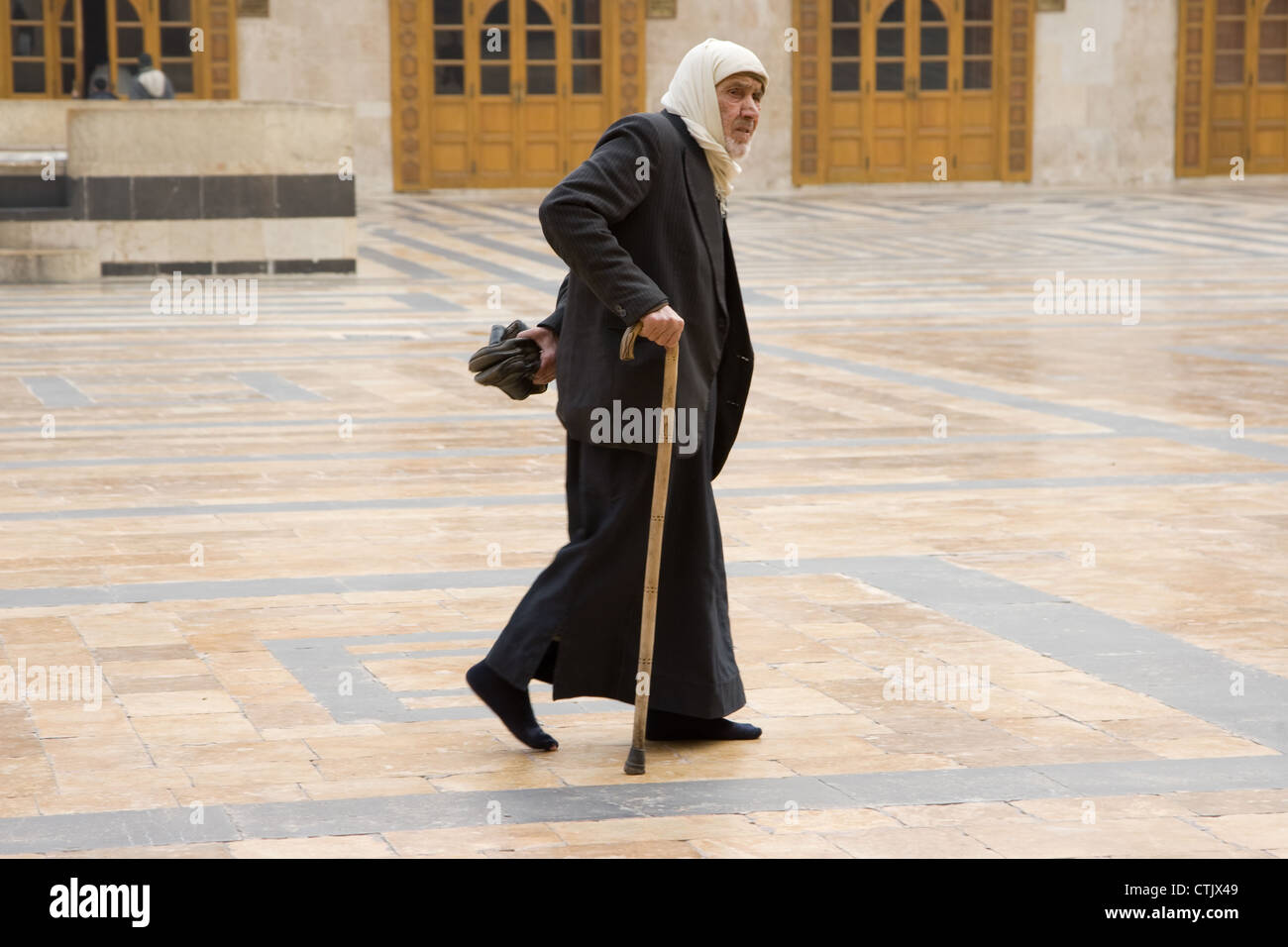 Old man walking on floor during prayer at the Great Mosque of Aleppo ...
