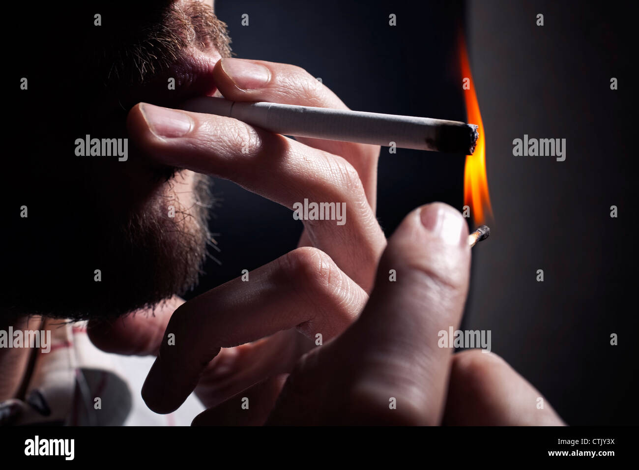 Men's hand lights a cigarette with a match closeup Stock Photo - Alamy