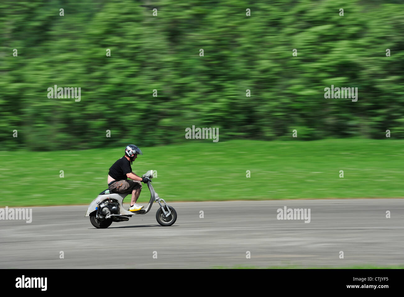 Scooter rider. Motion blur on wheels and background Stock Photo - Alamy