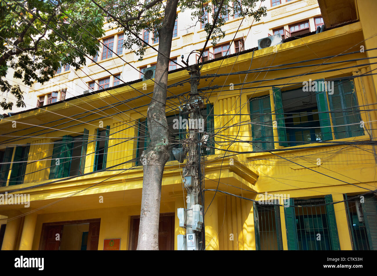 Electric wires in front of a yellow building Stock Photo - Alamy