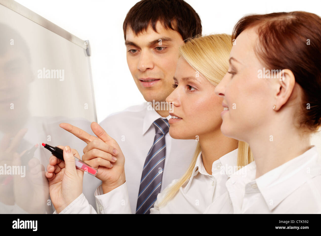 Business intern pointing at whiteboard and asking her boss to explain ...