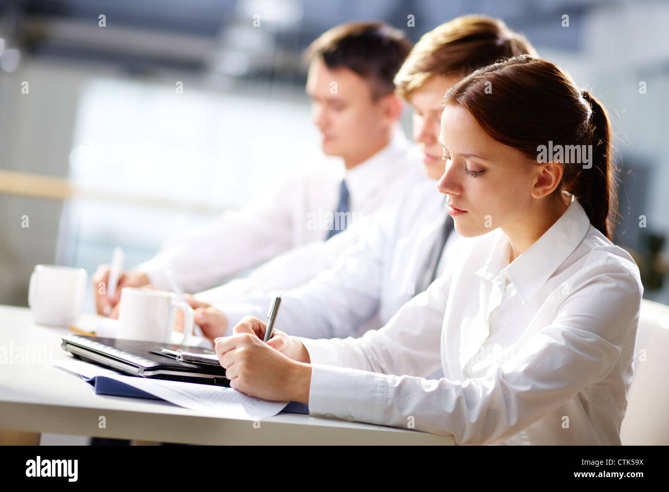 Group of business people taking notes at training Stock Photo - Alamy