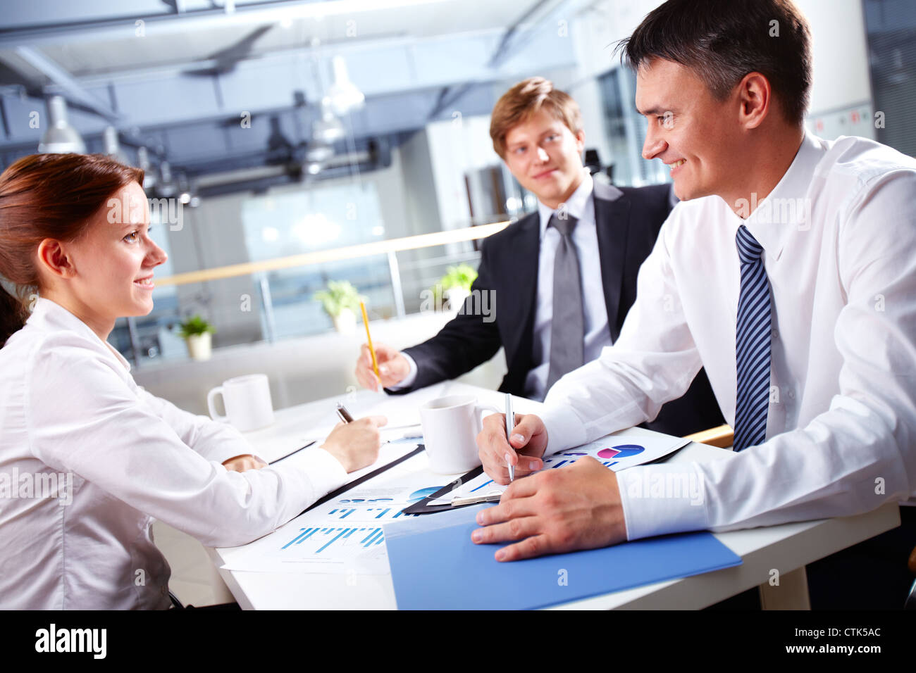 Positive business people exchanging affectionate looks Stock Photo - Alamy