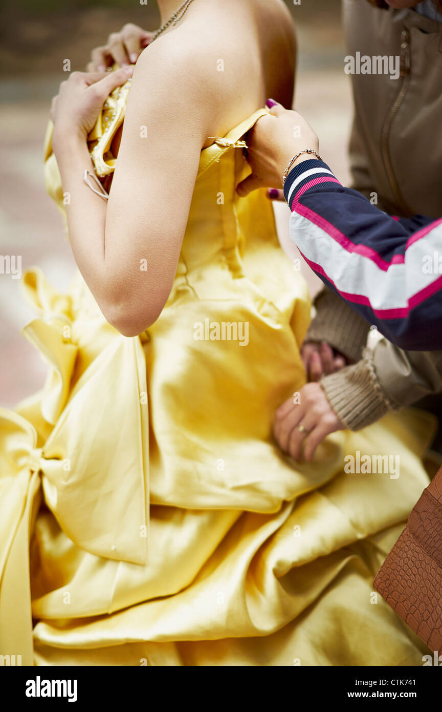 An ornate dress worn by a bridesmaid being fastened from behind Stock ...