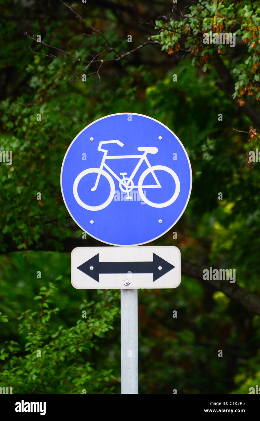 Bicycle sign in park with arrow in both directions Stock Photo - Alamy