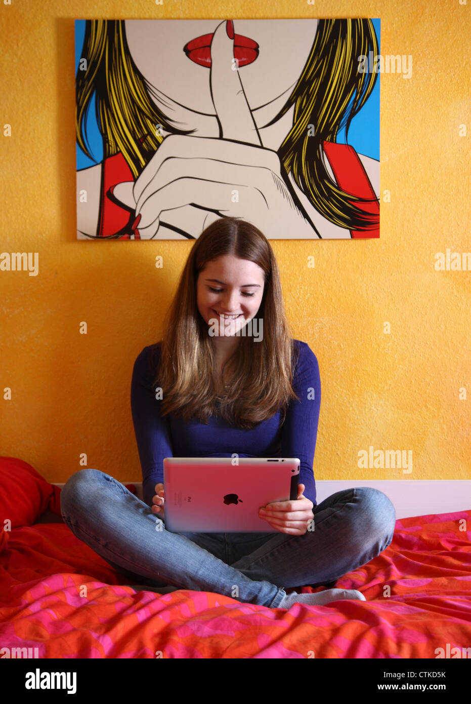 Young girl at home, using an IPad, tablet computer. Surfing the ...